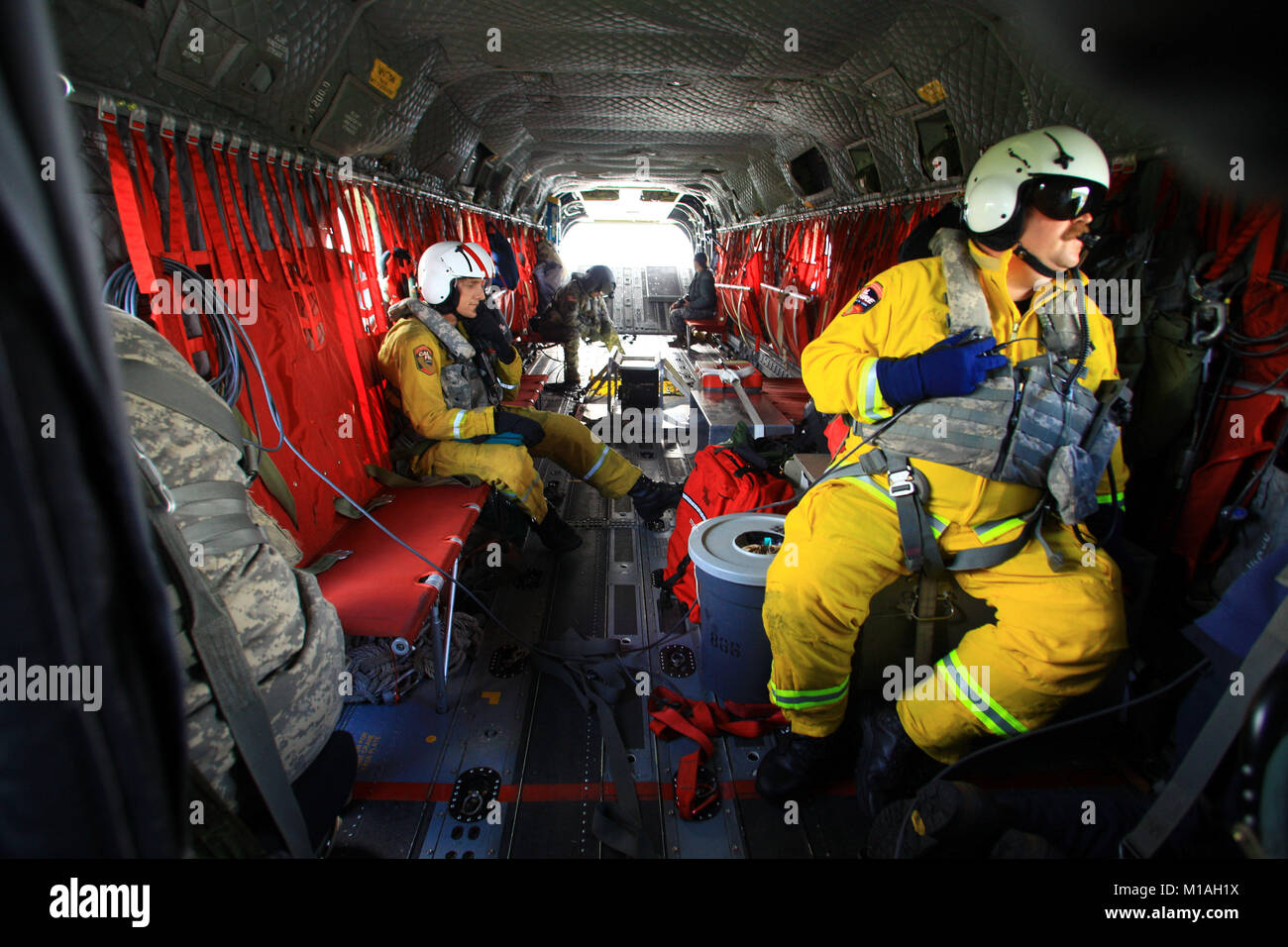 Tom Townsend of CALFIRE (right) looks out the window of a CH-47F ...