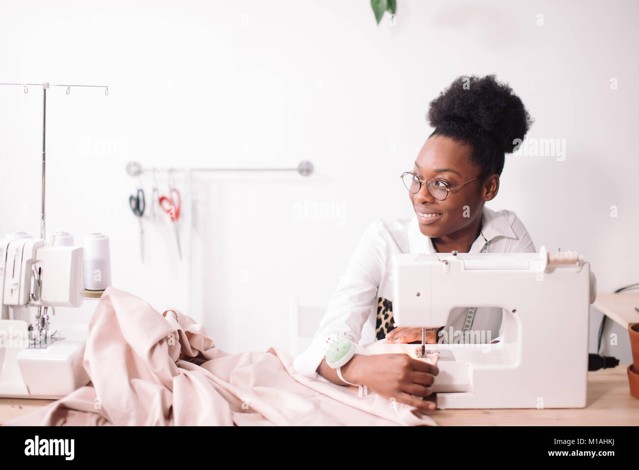 woman seamstress sitting and sews on sewing machine. Dressmaker working ...