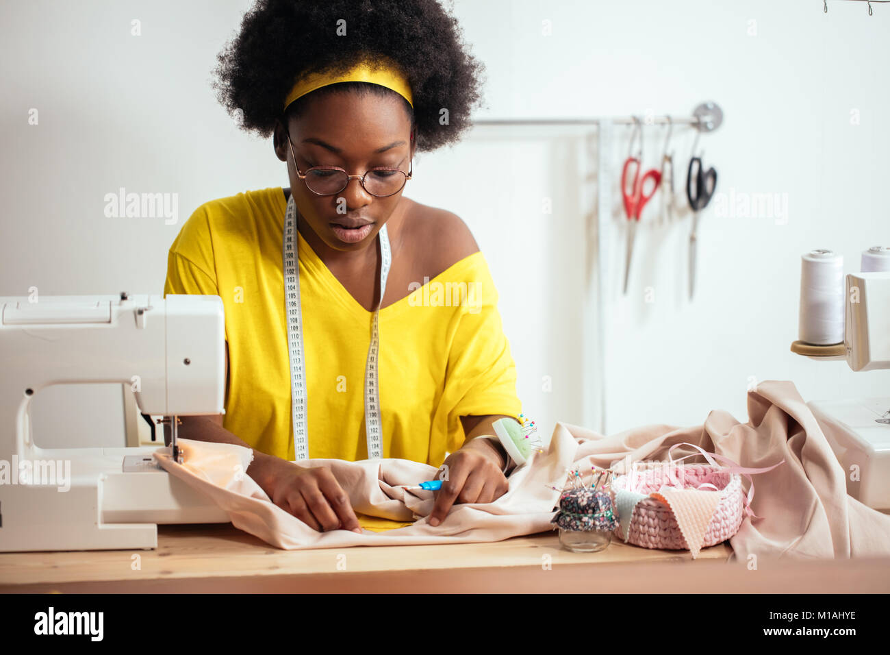 sewing fabric with needle at seamstress workplace Stock Photo - Alamy