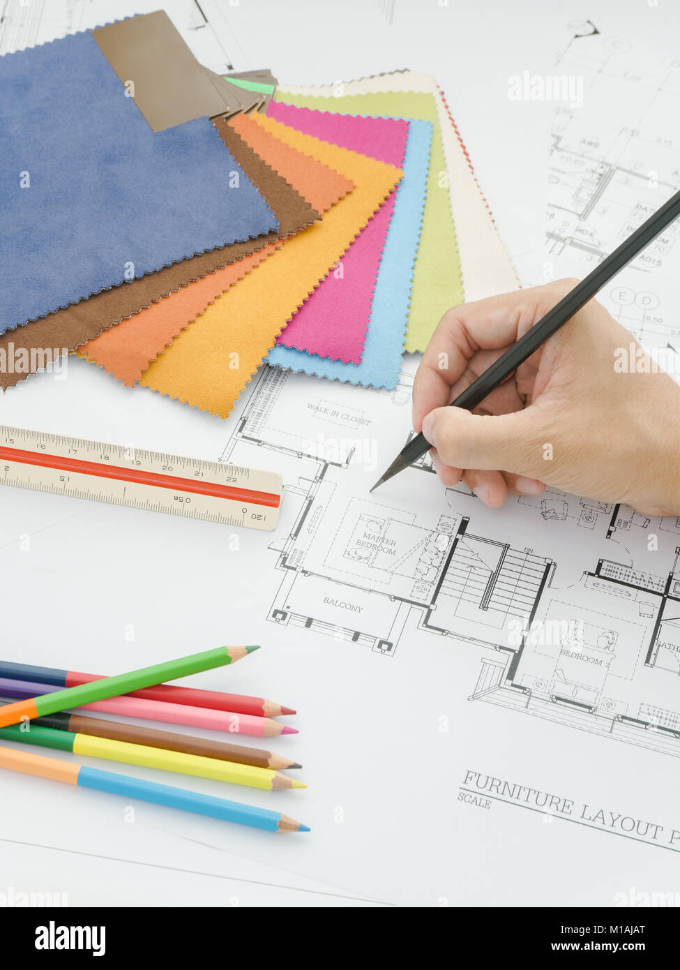 View of hand writing on architectural drawing with fabric sample, scale ...