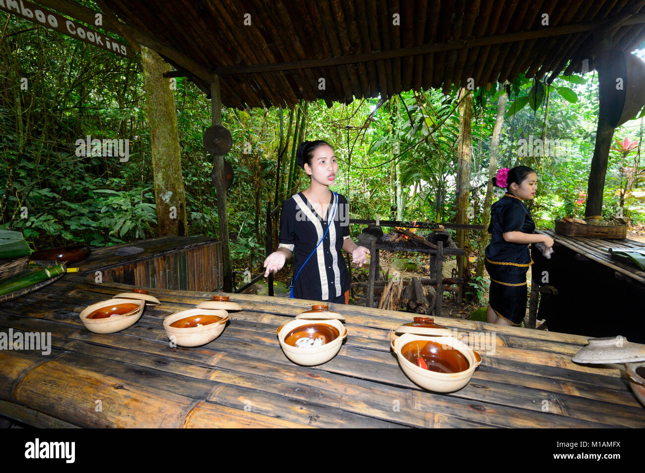 A young woman guide showing traditional food ingredients at Mari Mari ...