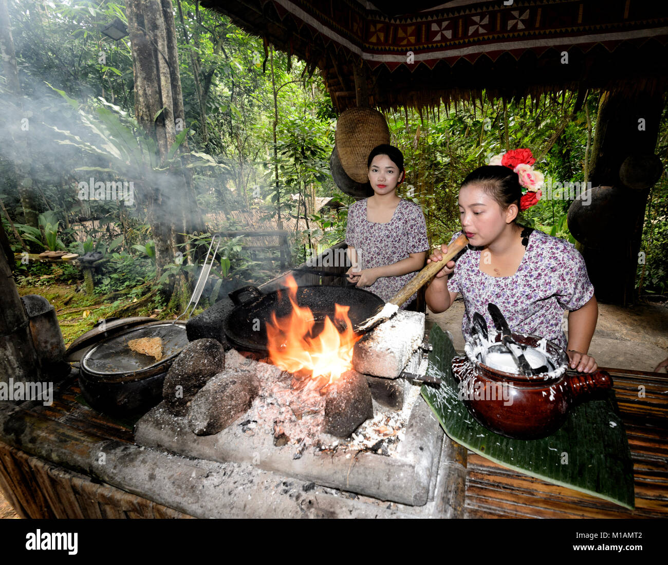 Two young Malaysian women showing how to make and cook rice noodles at ...