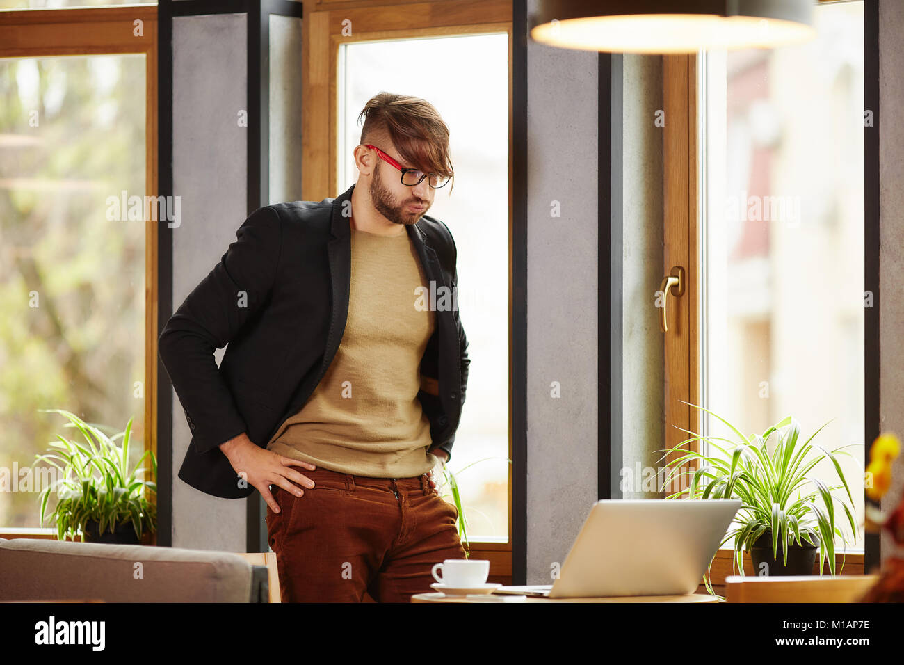 Thoughtful man standing at notebook Stock Photo - Alamy