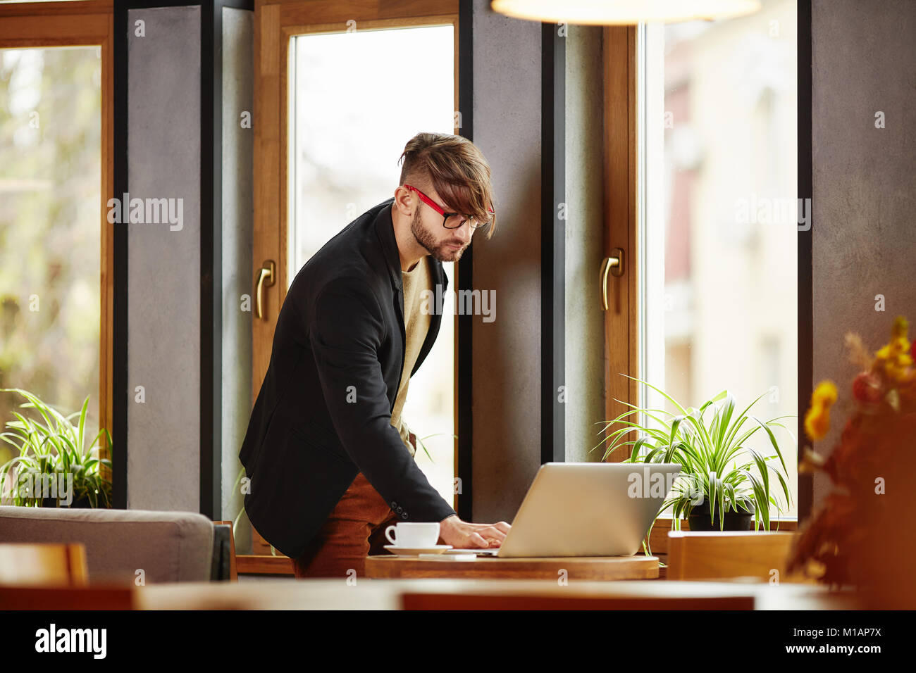 Thoughtful man standing at notebook Stock Photo - Alamy