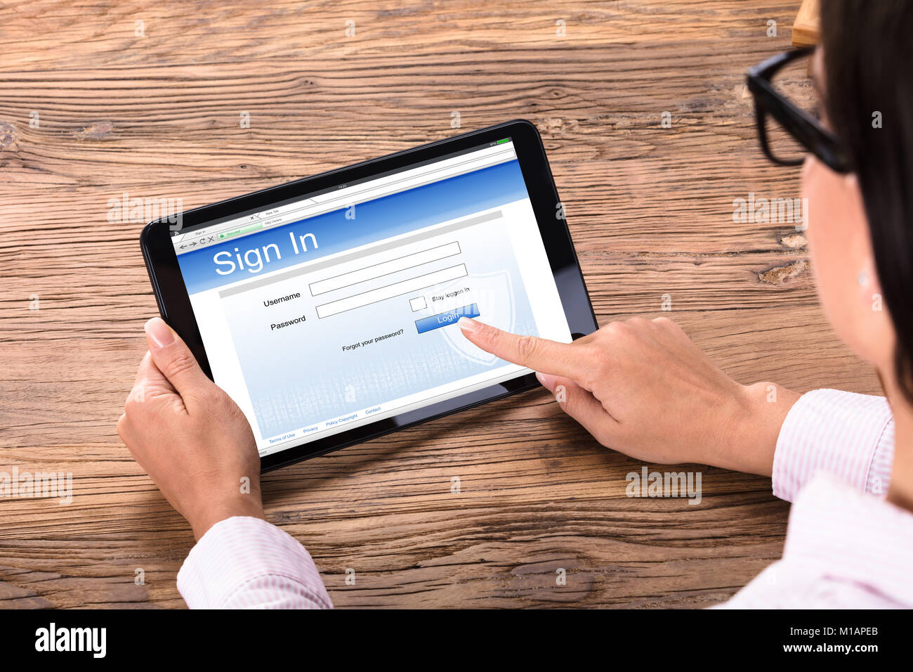 Businesswoman Touching Login Button On Digital Tablet At Wooden Desk ...