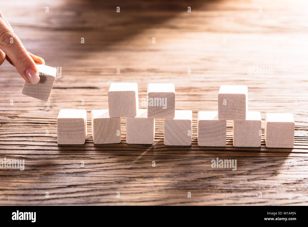 Woman stacking wooden block hi-res stock photography and images - Alamy