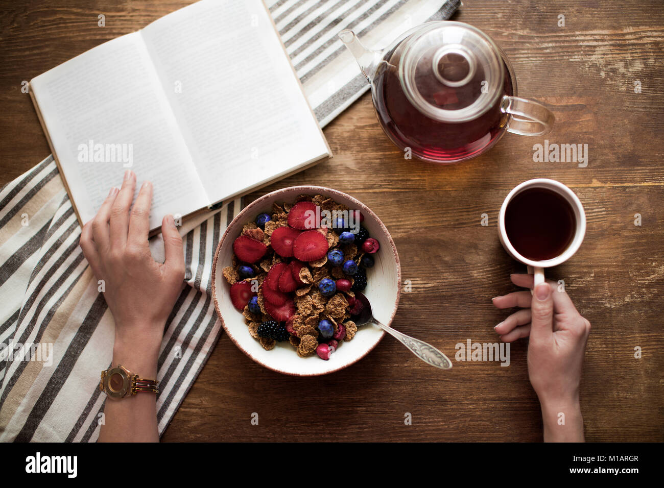 woman reading book during breakfast Stock Photo - Alamy