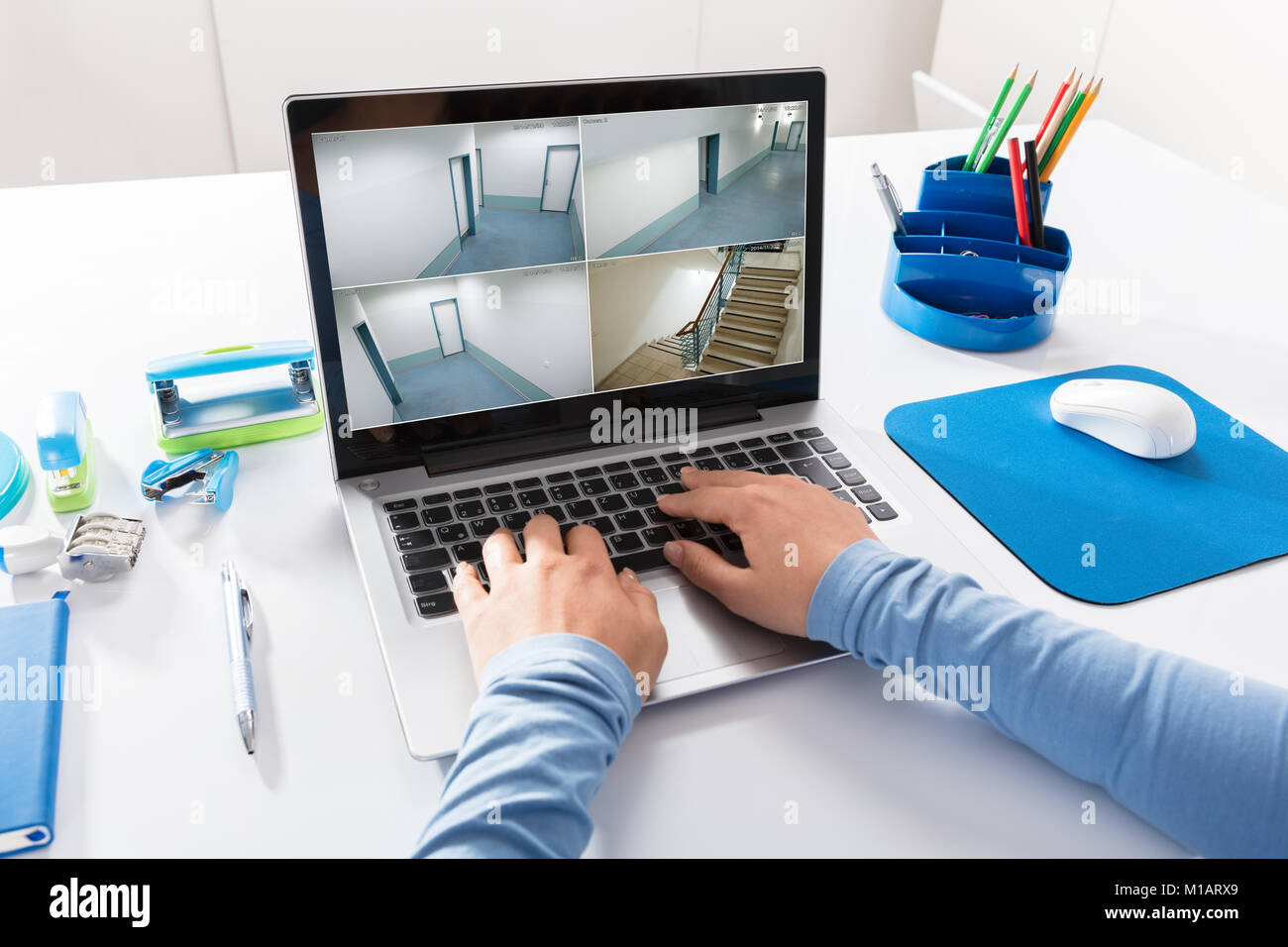 Businesswoman Watching CCTV Footage Of Office Interior On Laptop At ...