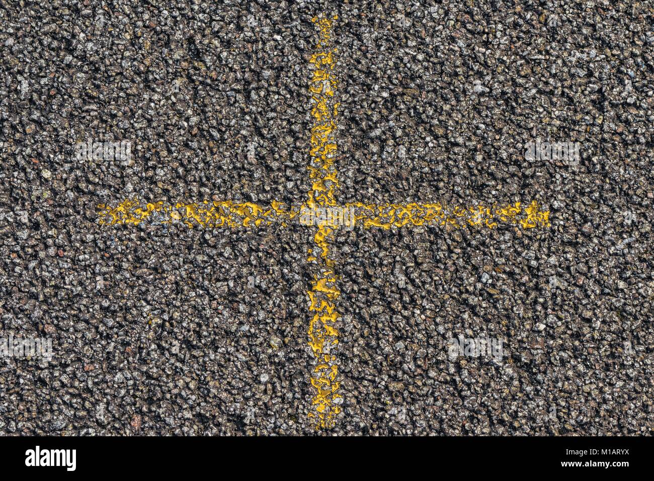 Yellow cross on asphalt Stock Photo - Alamy