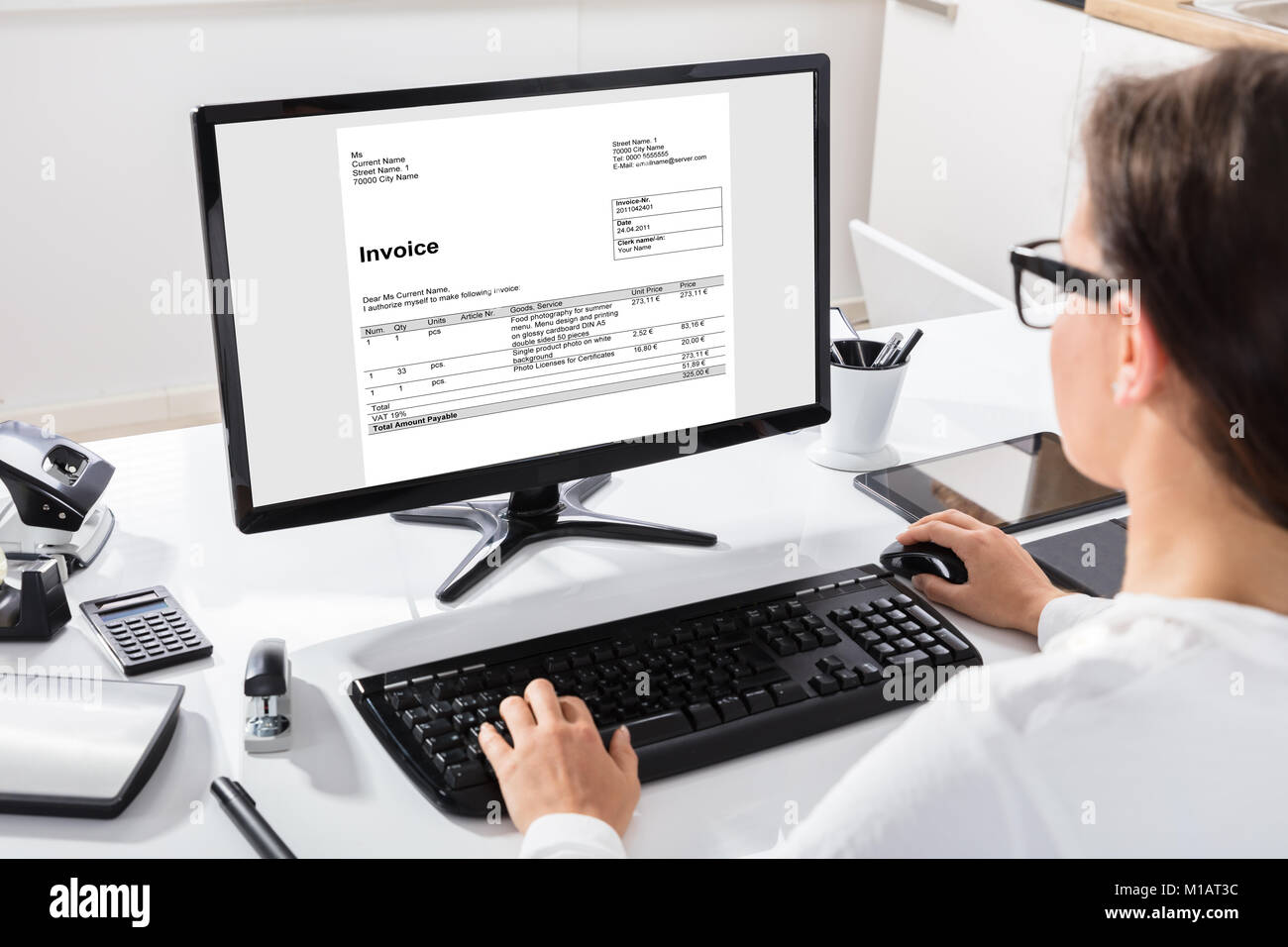 Rear View Of A Businesswoman Calculating Invoice On Computer At ...