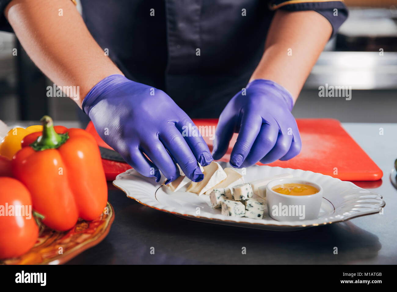 cropped shot of chef putting cheese slices on plate at restaurant Stock ...