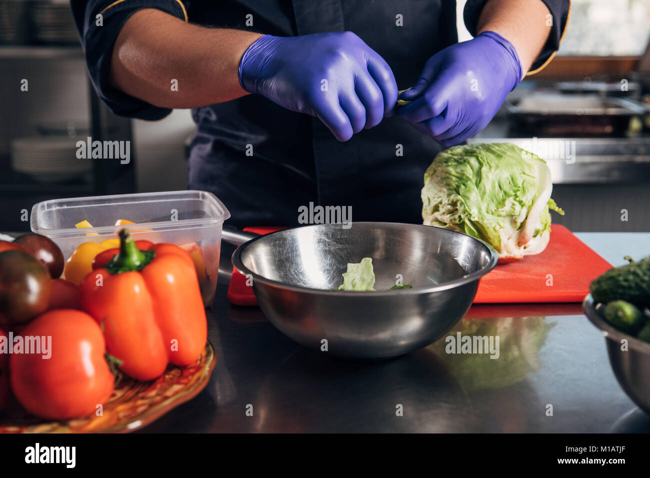 cropped shot of chef cooking vegetables at workplace in restaurant ...