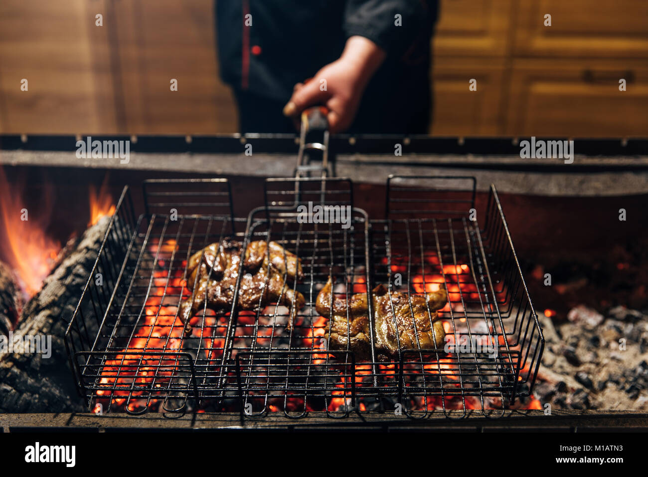 cropped shot of chef cooking meat on flame in grill bar Stock Photo - Alamy