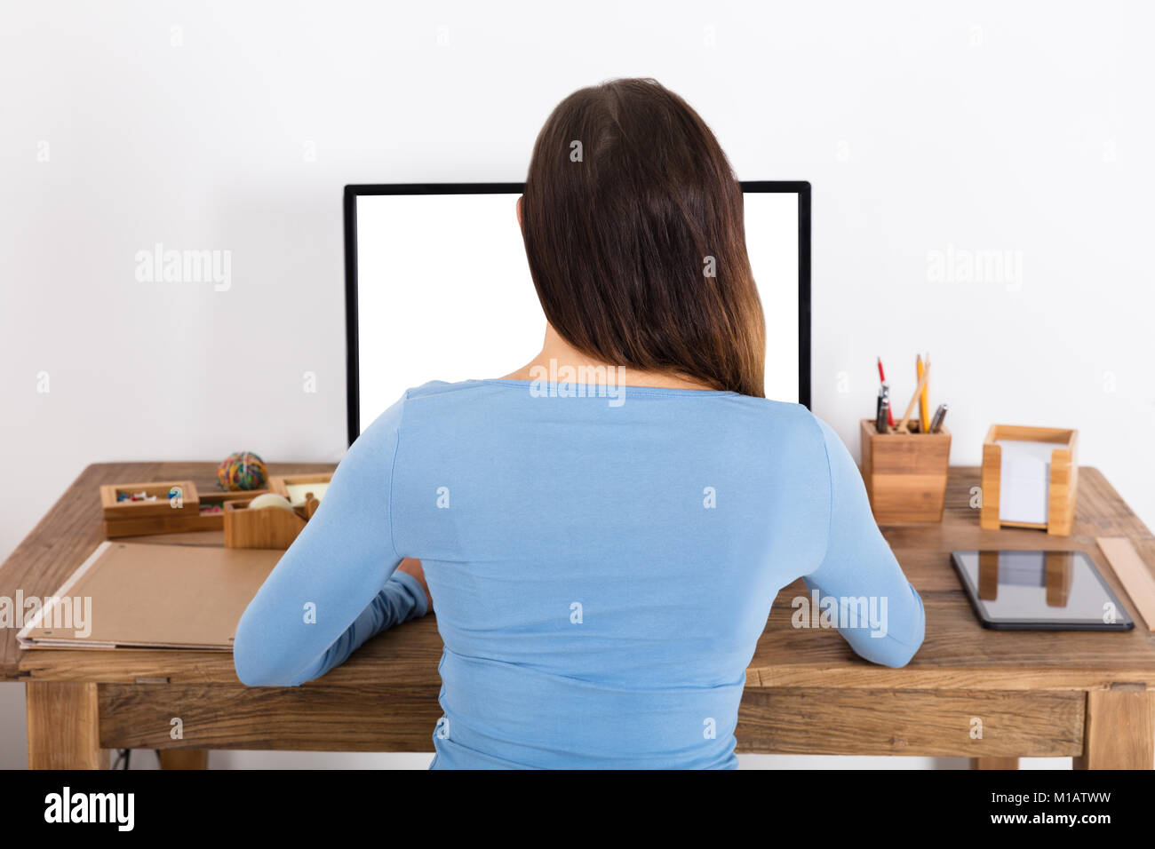 Rear View Of A Woman Sitting In Front Of Desktop At Home Stock Photo ...