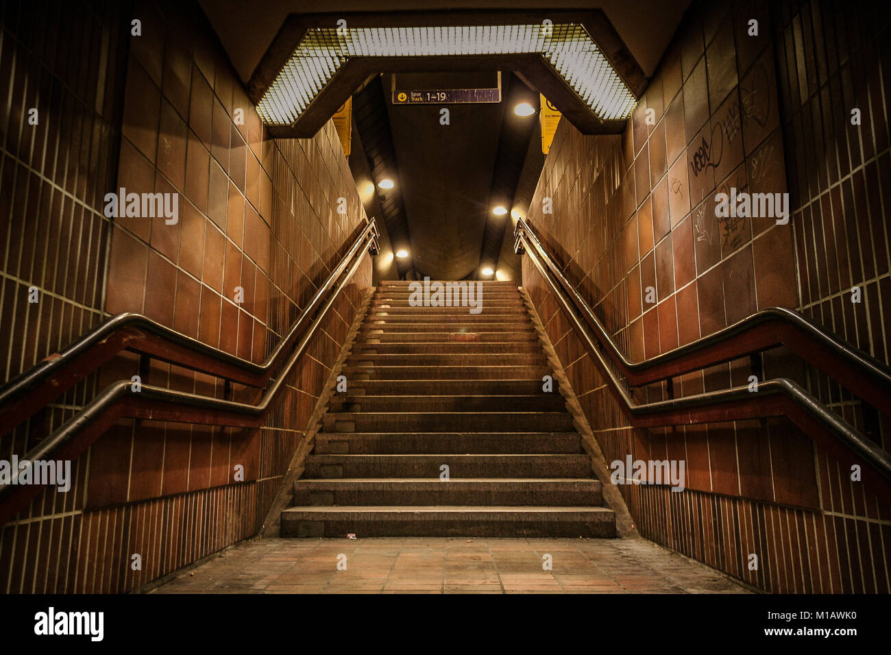 Stairs leading up from underground tunnel at a train station. Brown ...