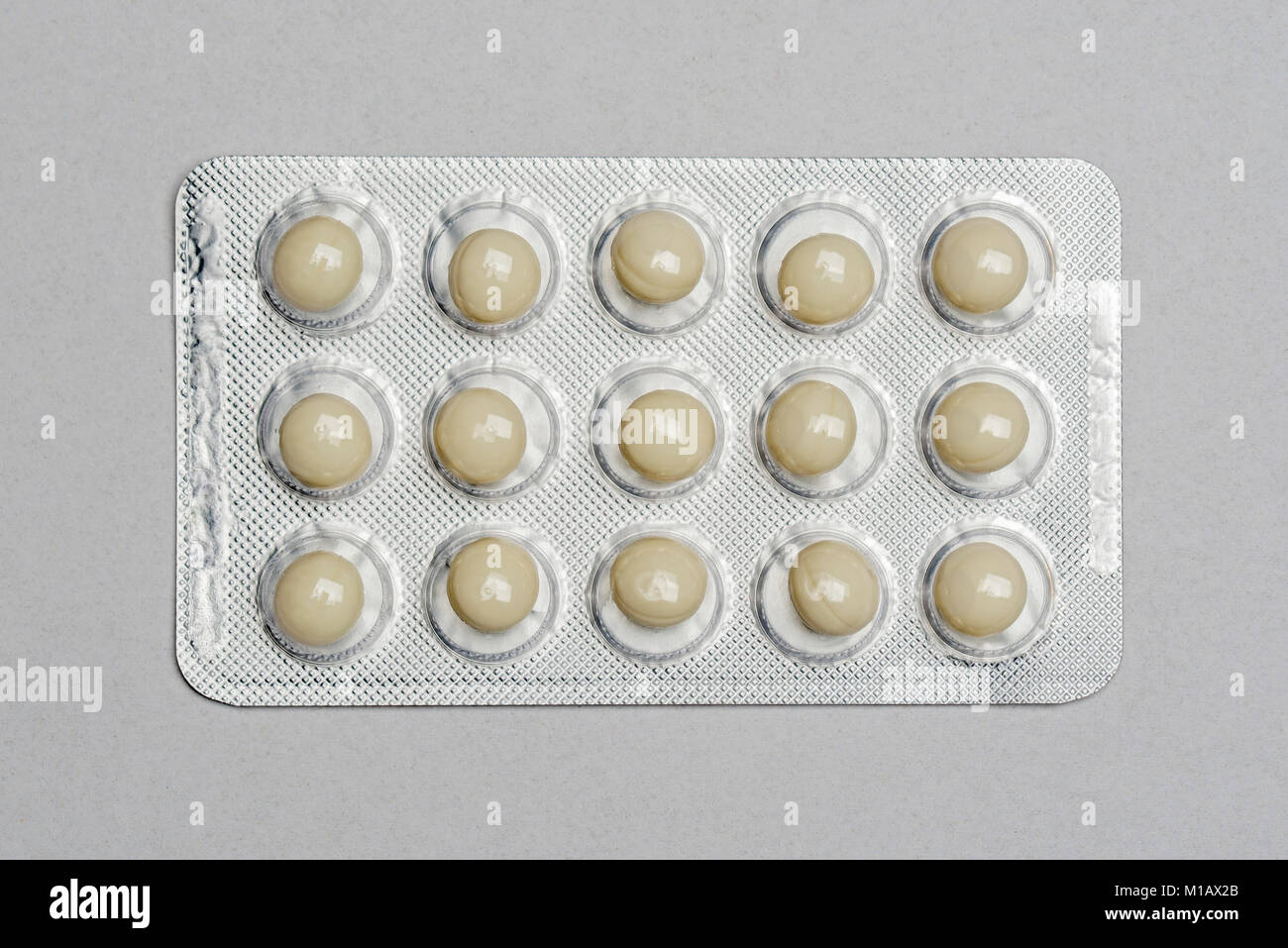 Pills in a pack on gray paper background Stock Photo - Alamy