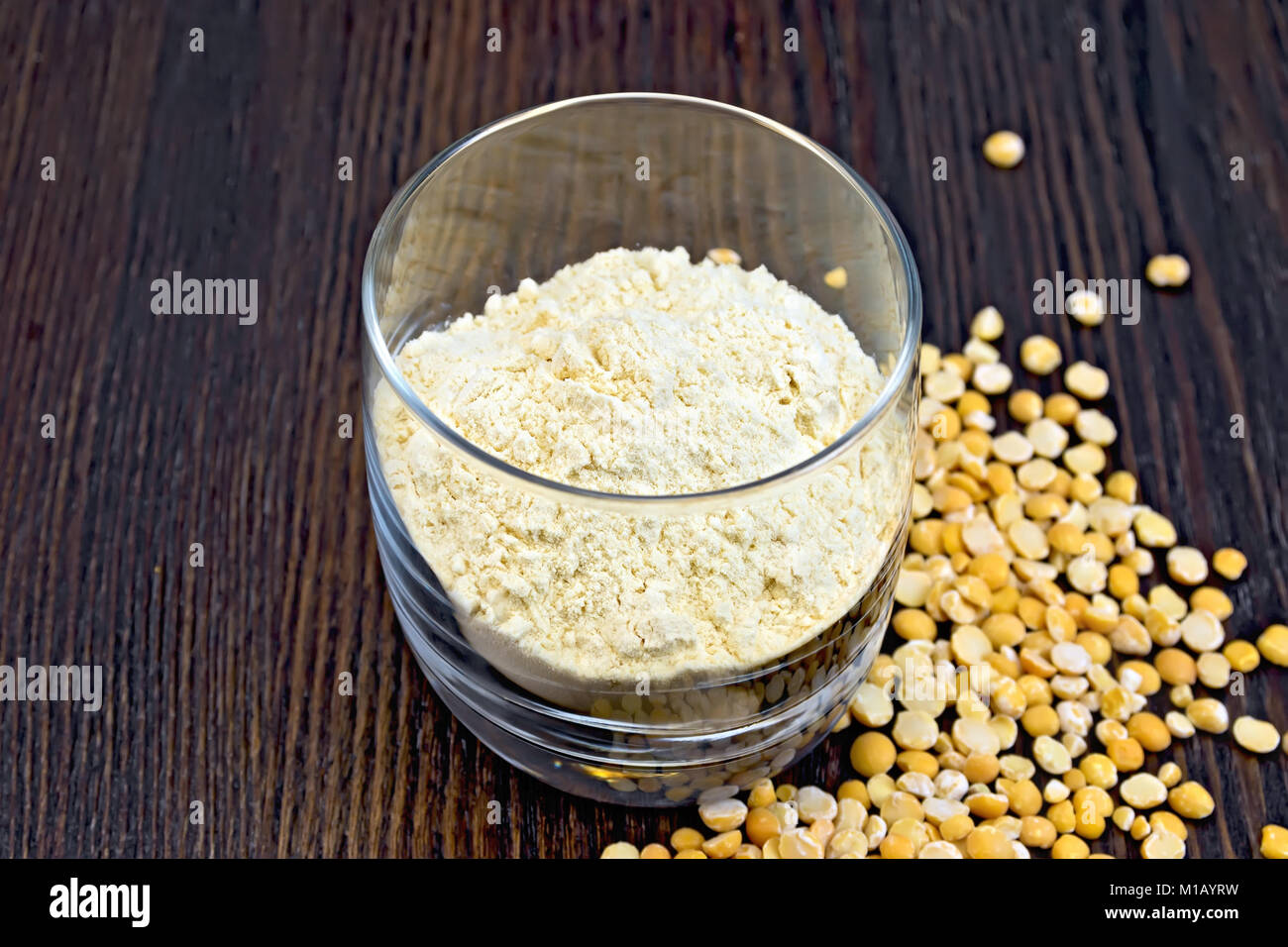 Flour pea in a glassful, split pease on a wooden boards background ...