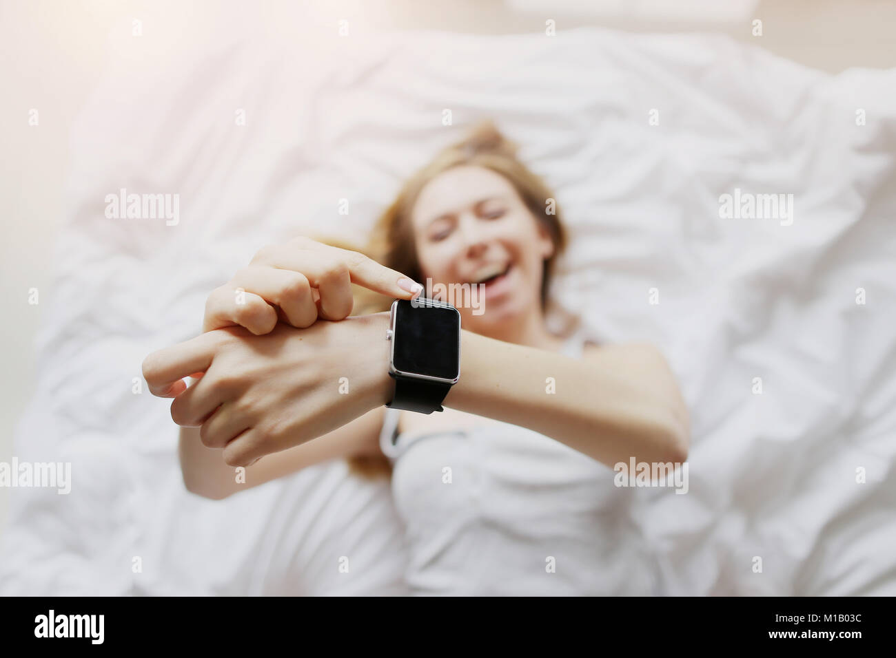 focus on smartwatches showing by young woman lay on white bed Stock ...