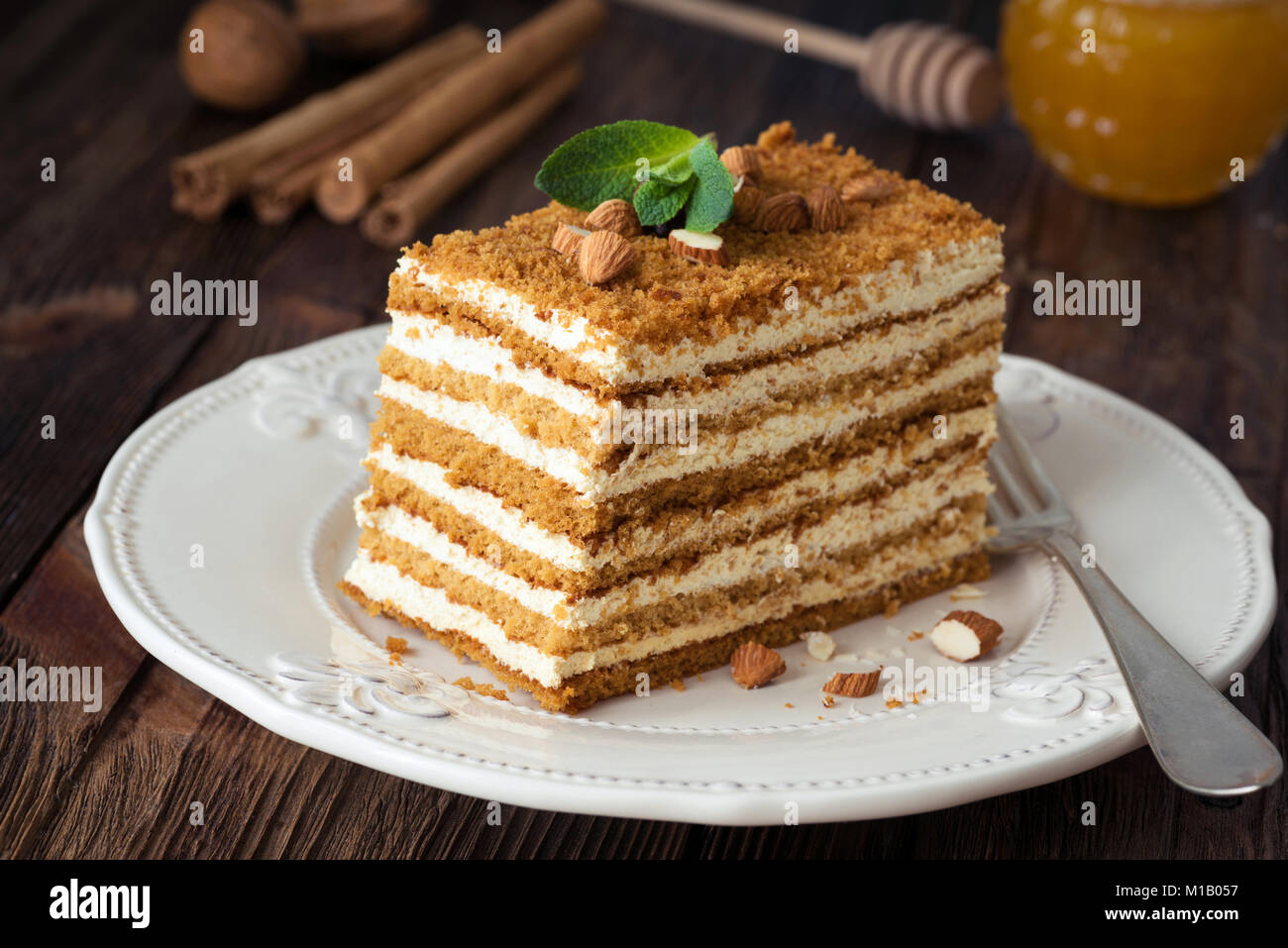 Slice of layered honey cake russian Medovik decorated with mint and ...