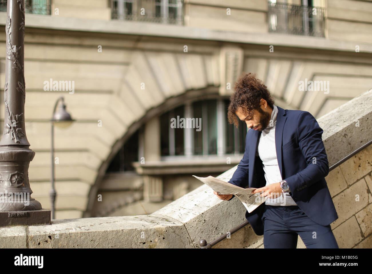 Young male model reading newspaper on open air Stock Photo - Alamy