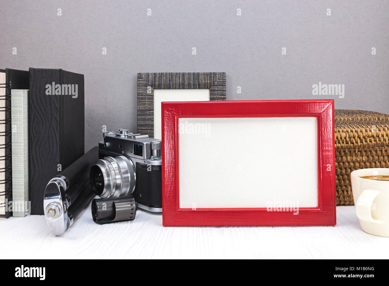 empty red photo frame, classic camera with equipment and photo albums ...