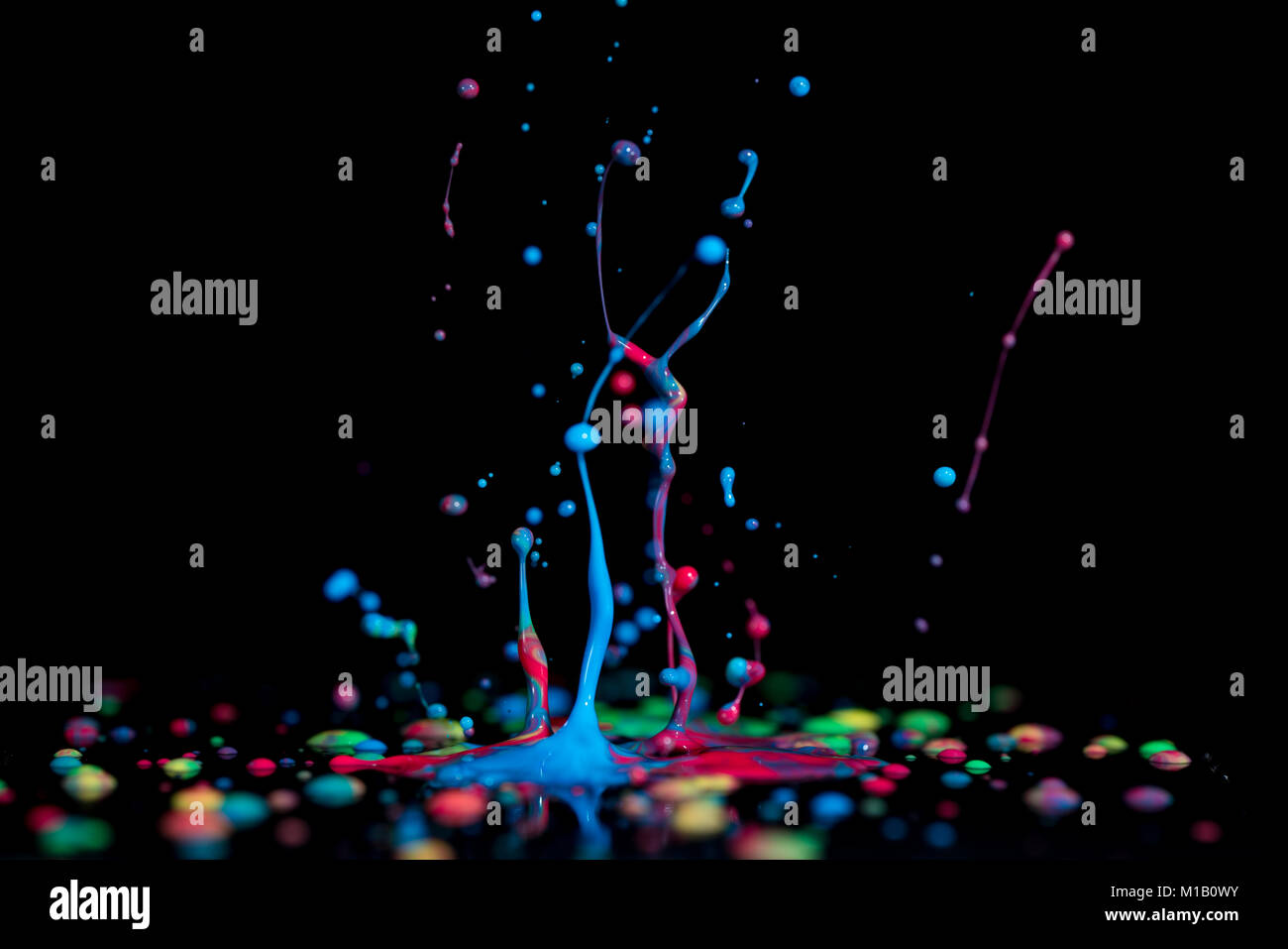 Splash of colorful liquid paint on a black background paint splash on ...