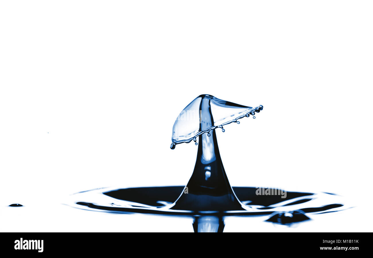 Splash and crown on rippled blue liquid or water surface . Water splash ...