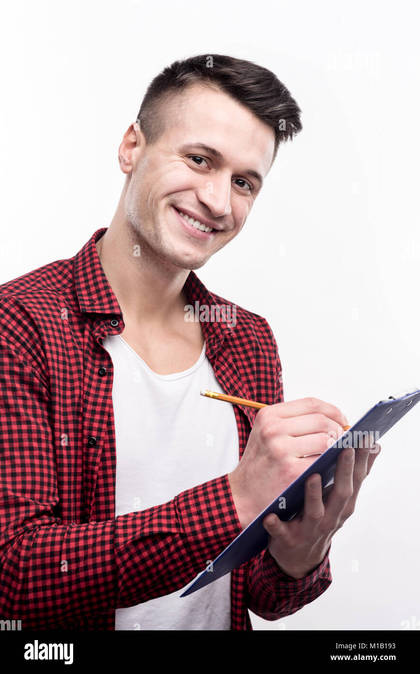 Pleasant man taking notes on sheet holder Stock Photo - Alamy