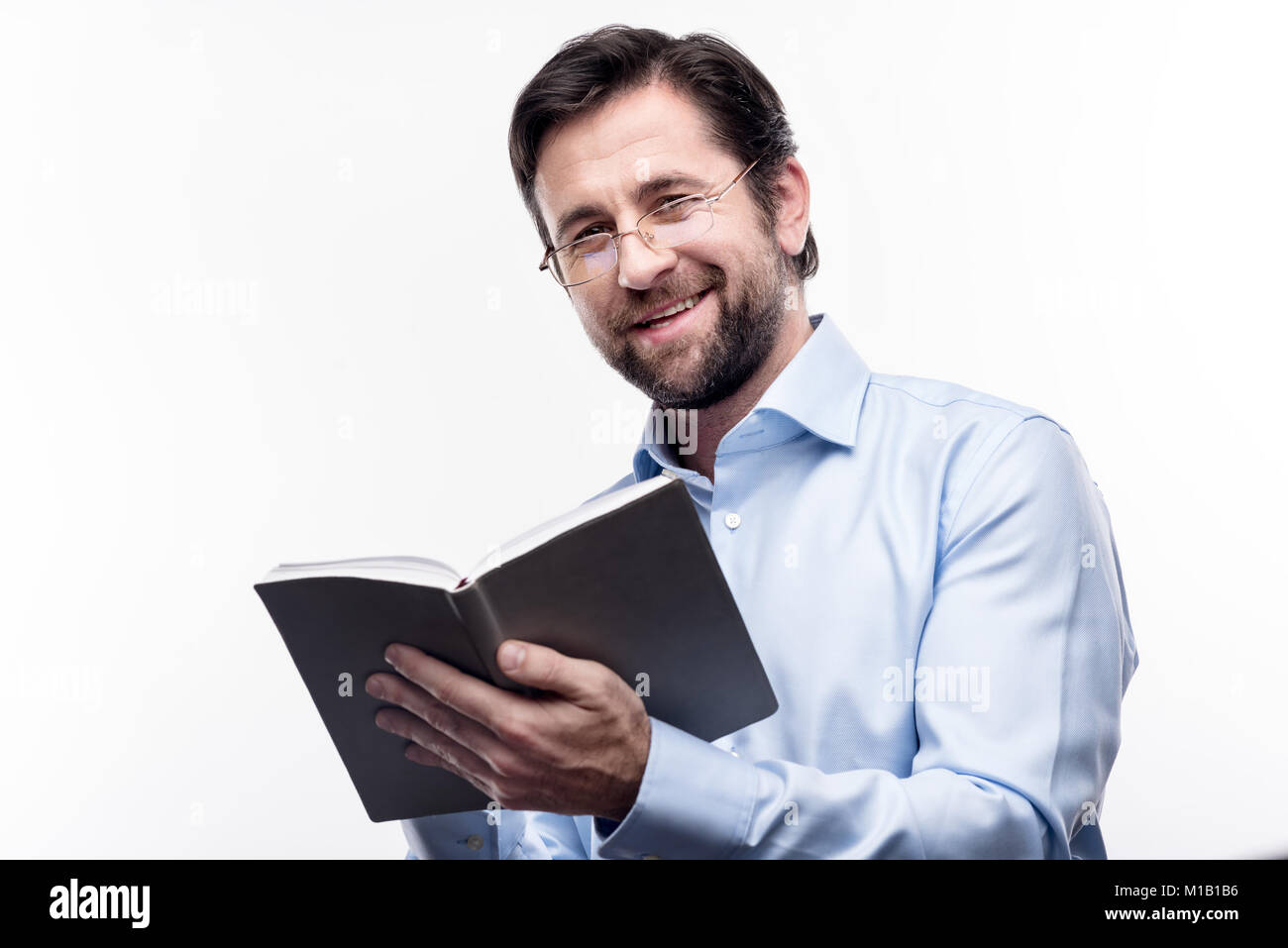Smiling professor writing in his notebook Stock Photo - Alamy