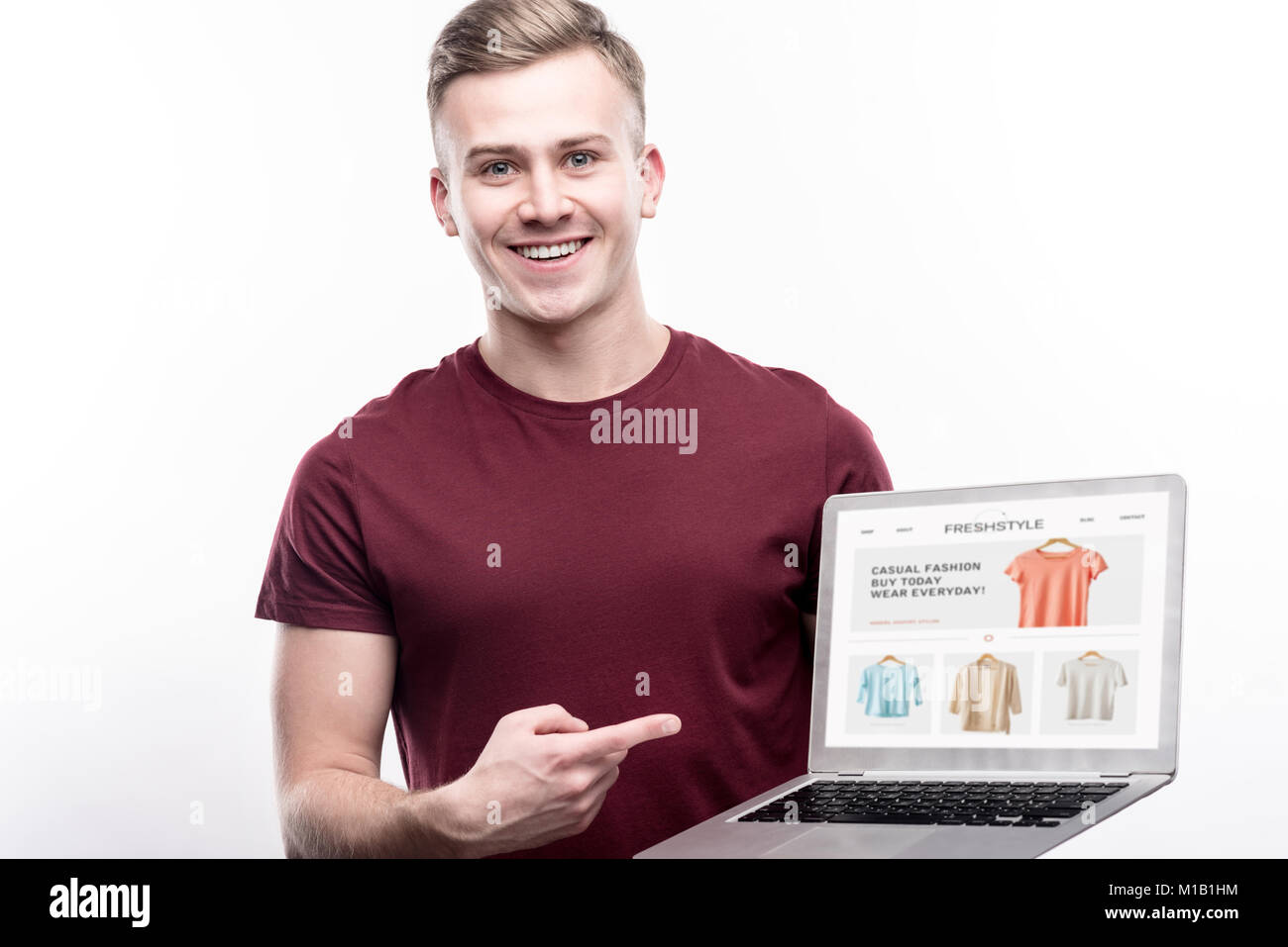 Charming man showing website of online clothes shop Stock Photo - Alamy