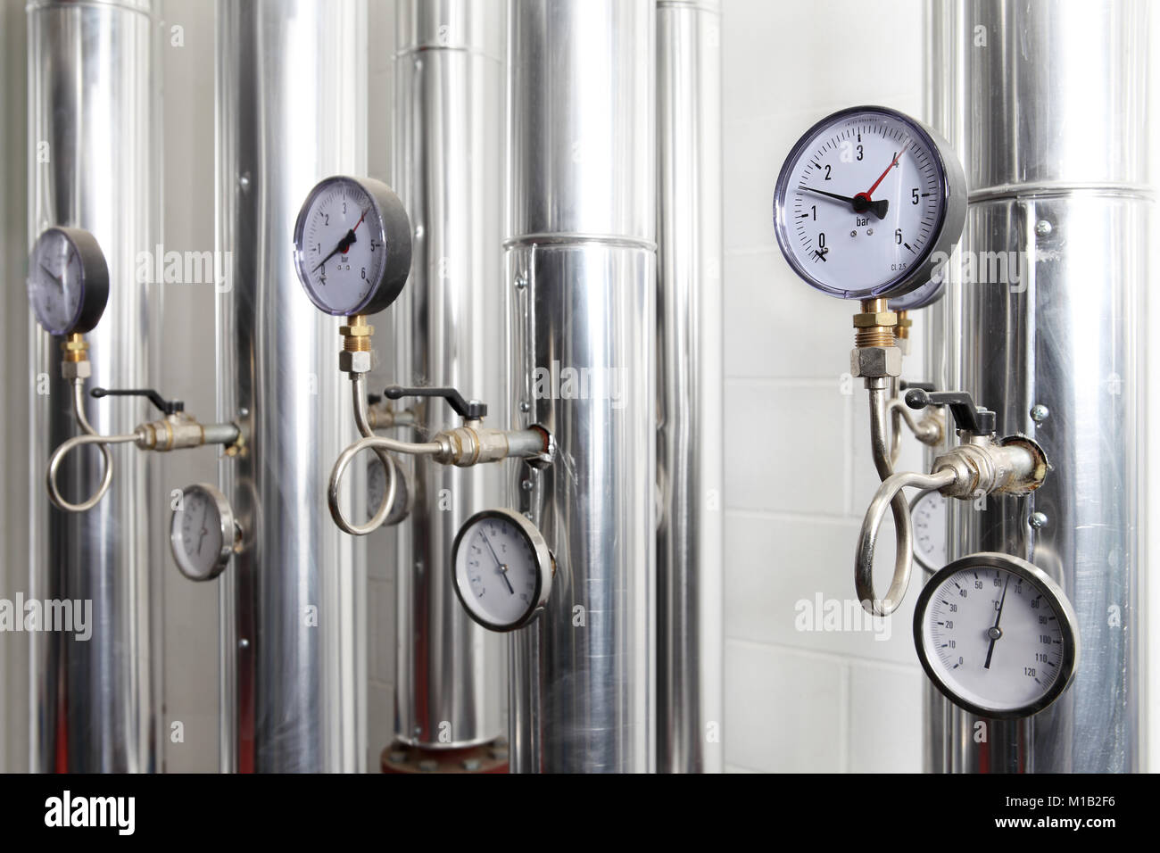 manometer, pipes and faucet valves of heating system in a boiler room ...