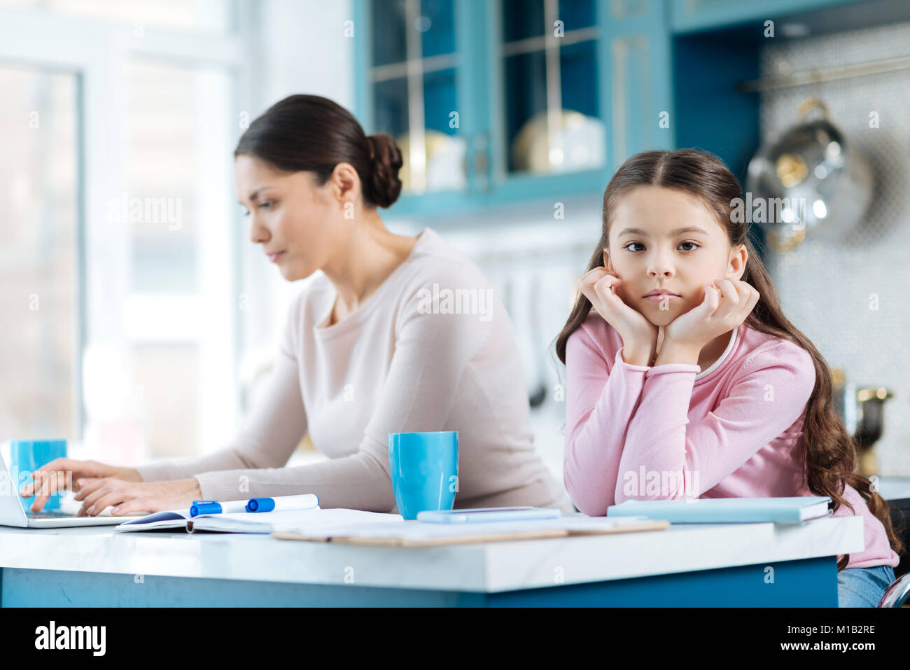 Bored child standing near her mom working Stock Photo - Alamy