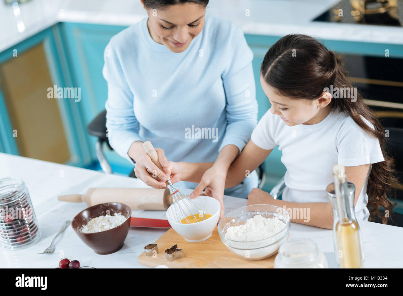 Smiling mother and daughter making a pie Stock Photo - Alamy