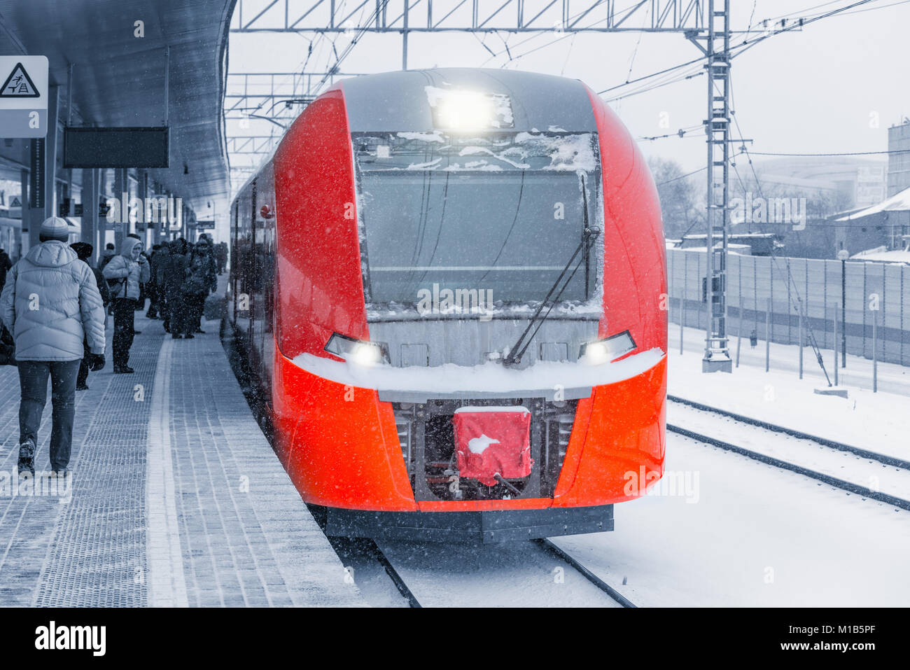 Highspeed train stands at the station platform at winter evening time ...