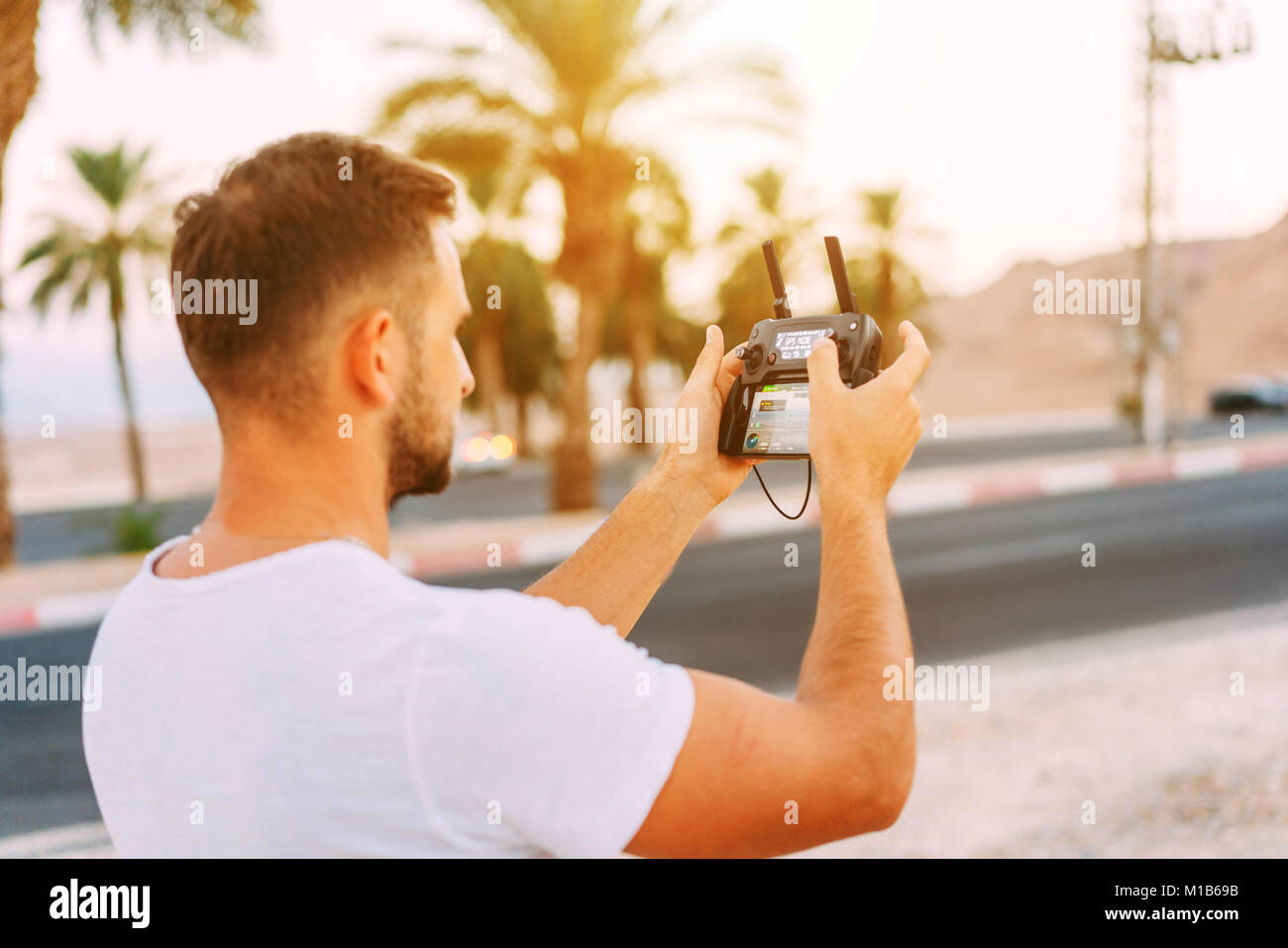 Guy controls drone with remote control Stock Photo - Alamy