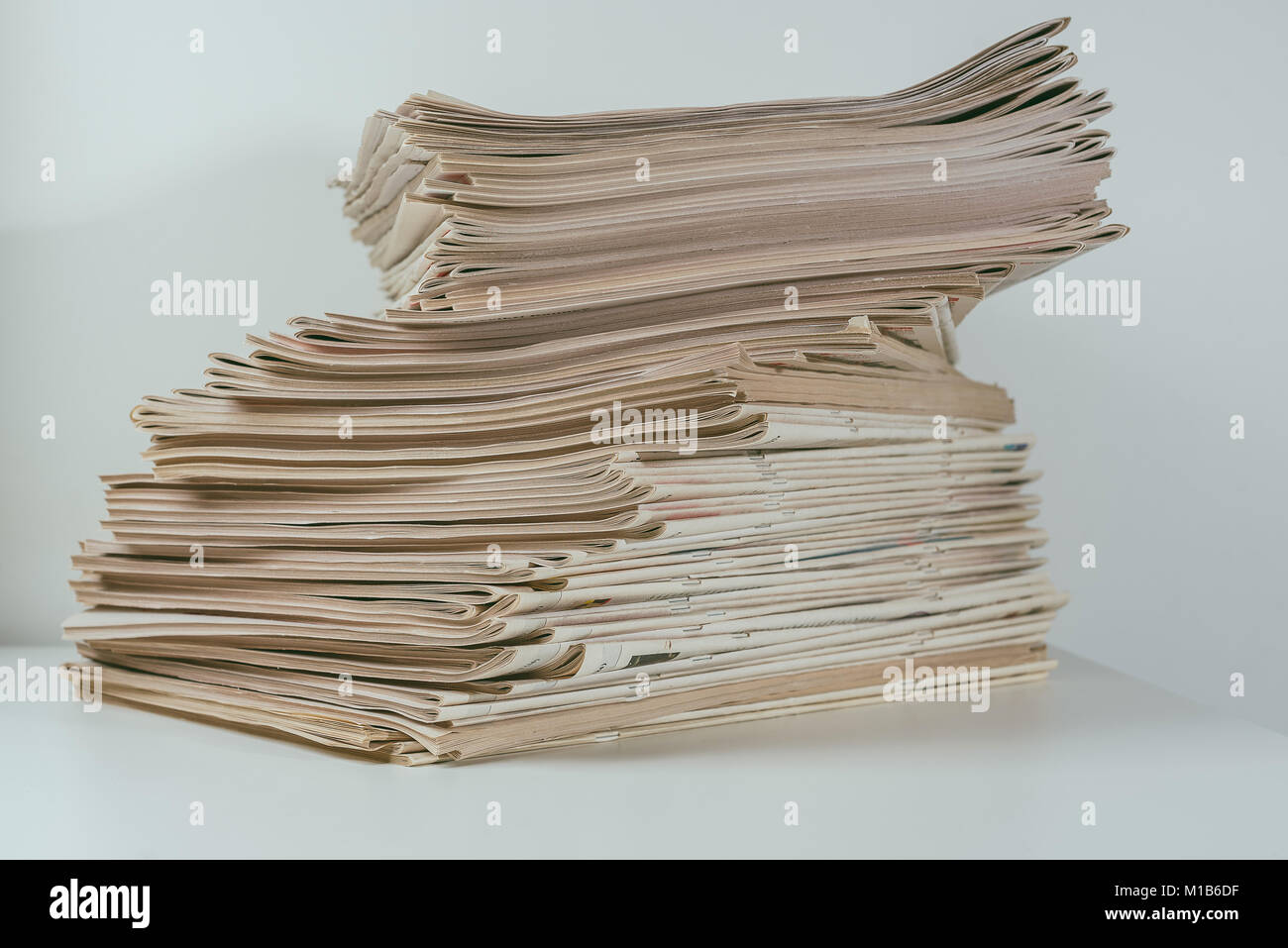 Stack of newspapers placed on white background Stock Photo - Alamy