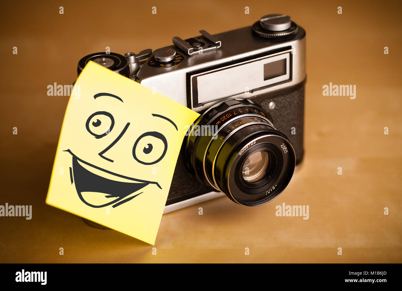 Drawn smiley face on a post-it note sticked on a photo camera Stock ...