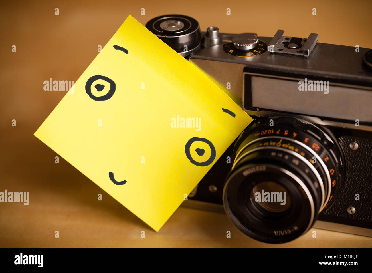 Drawn smiley face on a post-it note sticked on a photo camera Stock ...