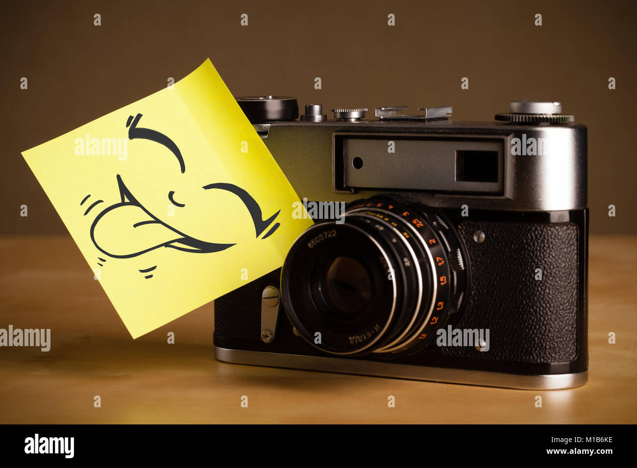 Drawn smiley face on a post-it note sticked on a photo camera Stock ...