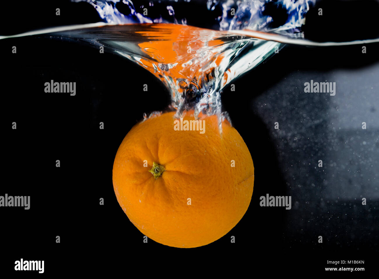 Orange splash in the water Stock Photo - Alamy