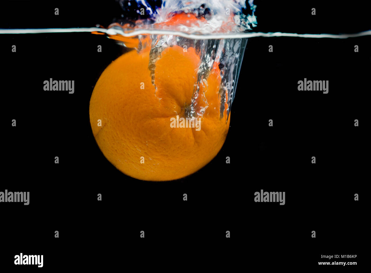 Orange splash in the water Stock Photo - Alamy