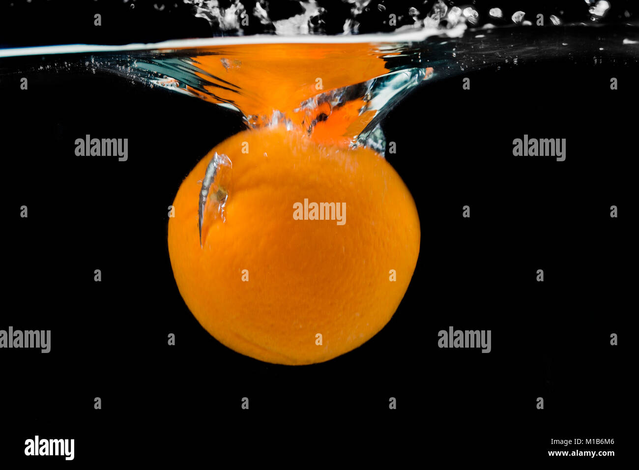 Orange splash in the water Stock Photo - Alamy