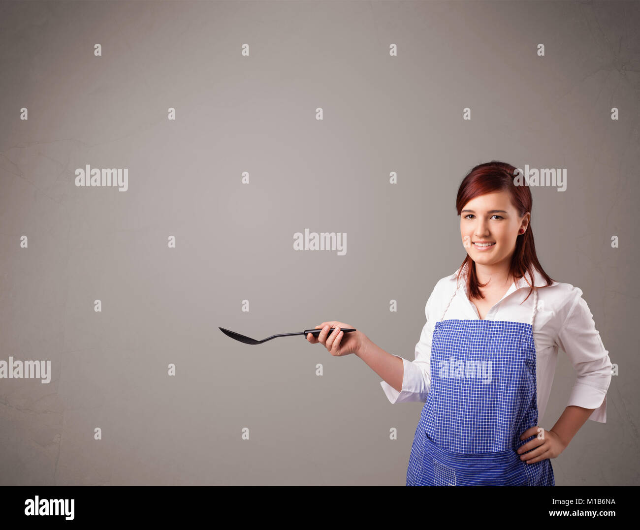 Beautiful young woman holding a spoon Stock Photo - Alamy