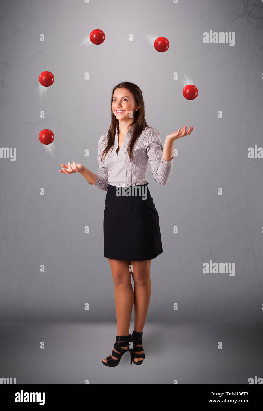 pretty young girl standing and juggling with red balls Stock Photo - Alamy