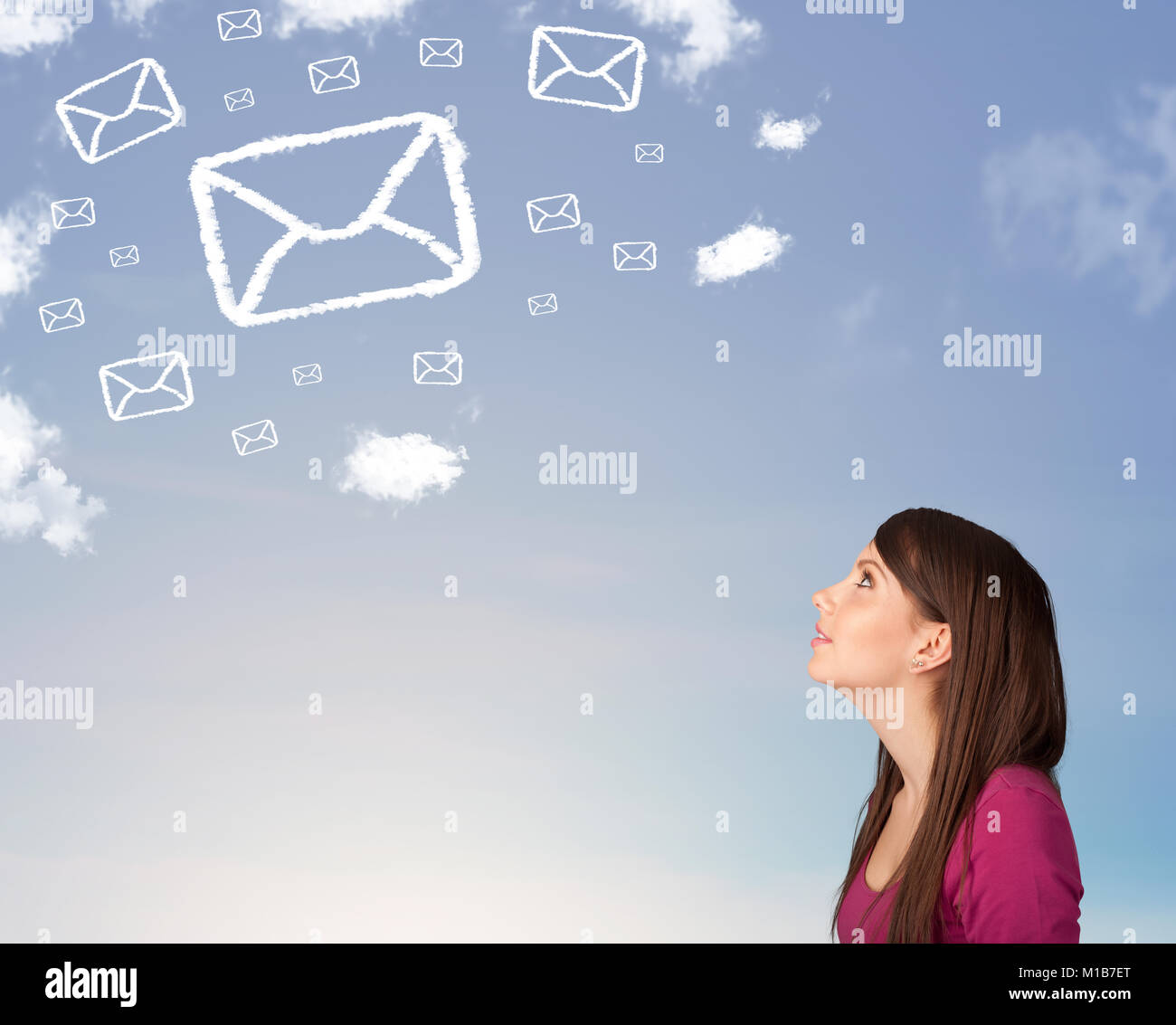Casual young girl looking at mail symbol clouds on blue sky Stock Photo ...