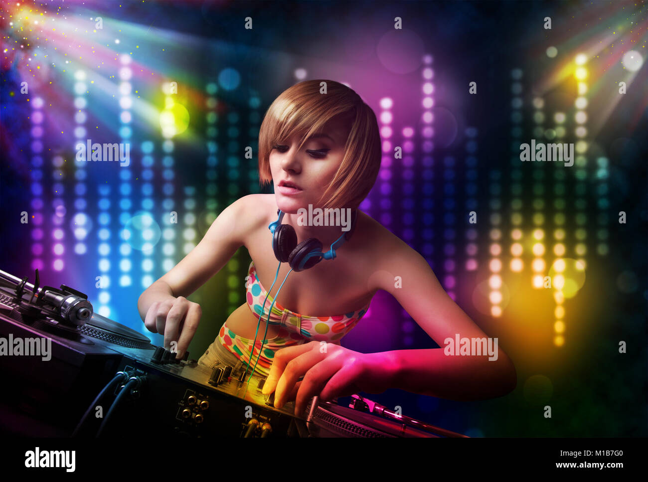 Pretty Dj girl playing songs in a disco with light show Stock Photo - Alamy