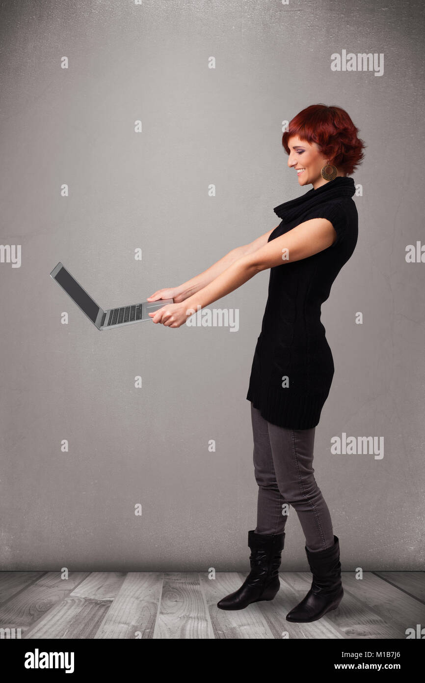 Pretty young woman holding modern laptot Stock Photo - Alamy
