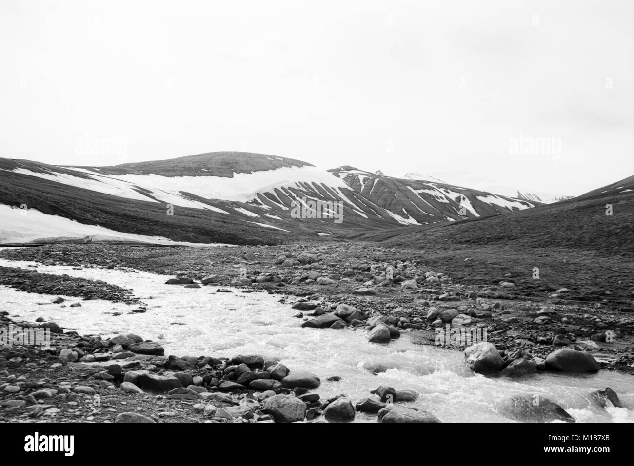 Standing at the side of a fast flowing arctic stream as it tumbles over ...