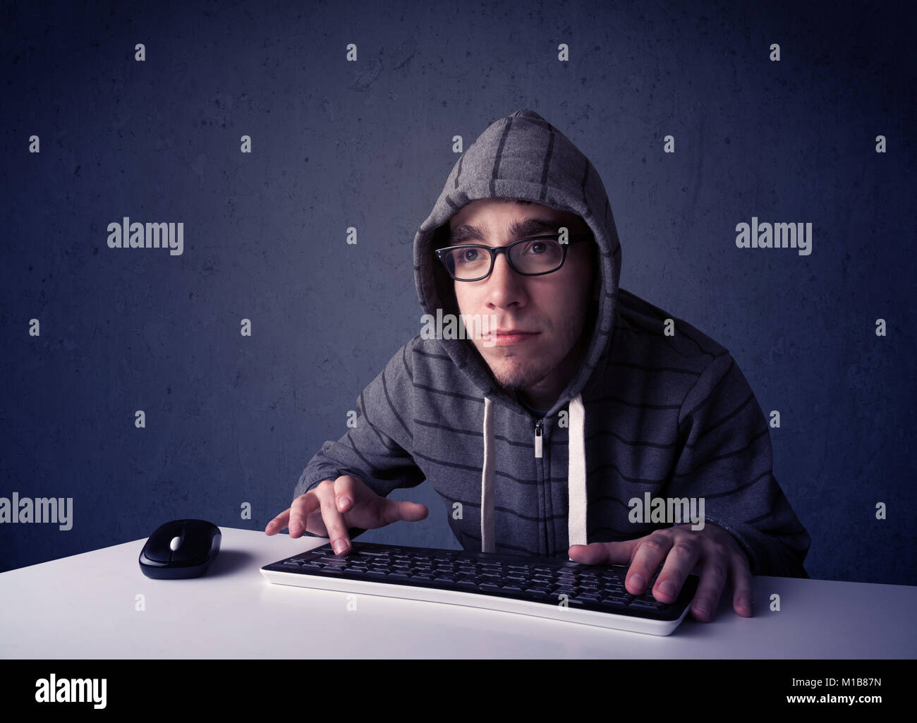 Hacker working with keyboard and mouse on blue background Stock Photo ...