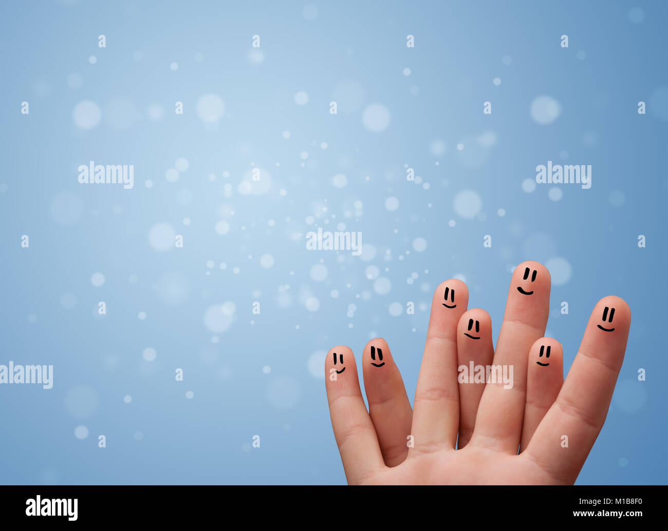 Happy finger smileys faces on hand with empty blue bokeh background ...